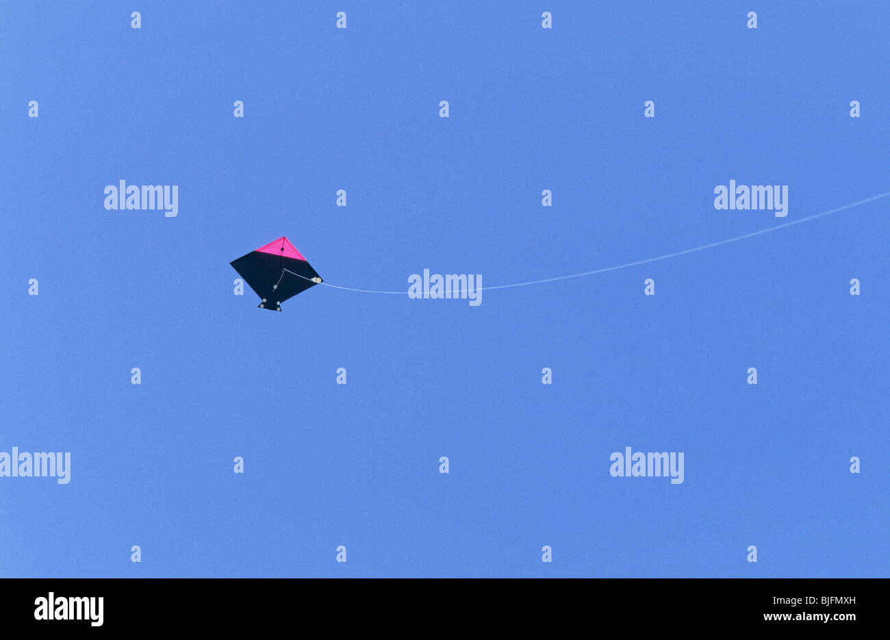 Blue Kite flying high in sky with trailing tail Stock Photo - Alamy