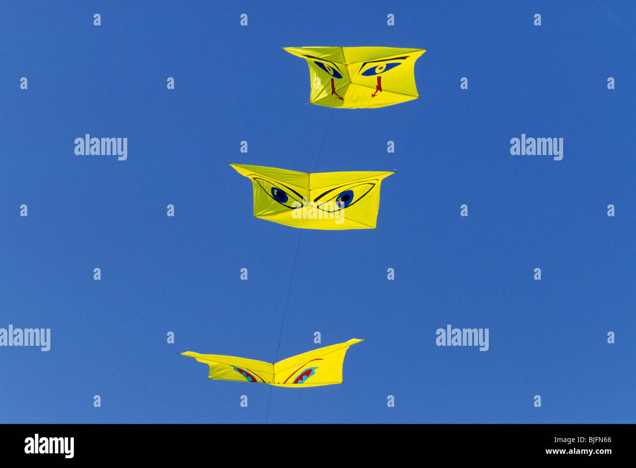 Yellow kites flying high in sky Stock Photo - Alamy