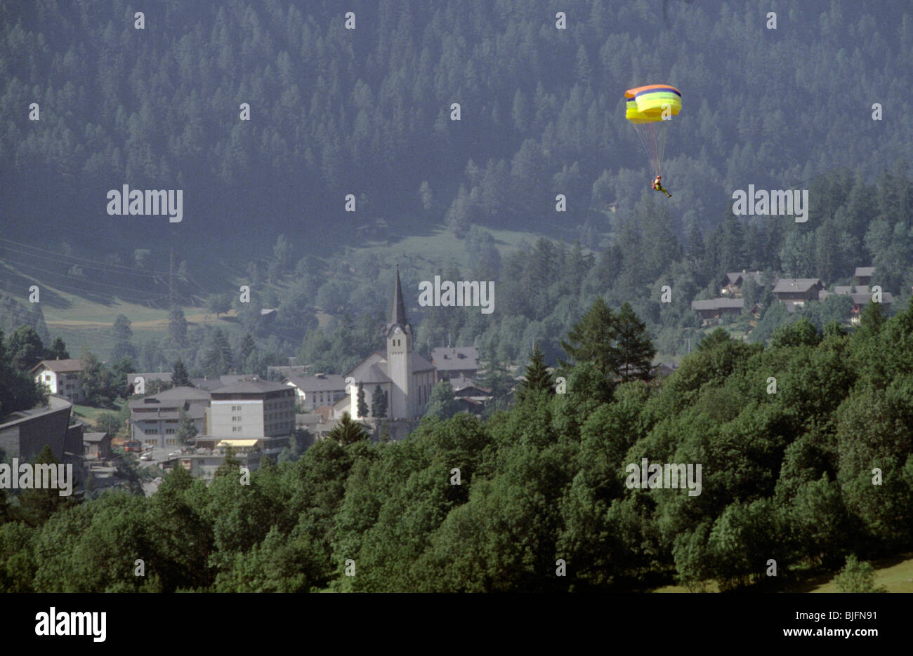 Para gliding over a valley town Stock Photo - Alamy
