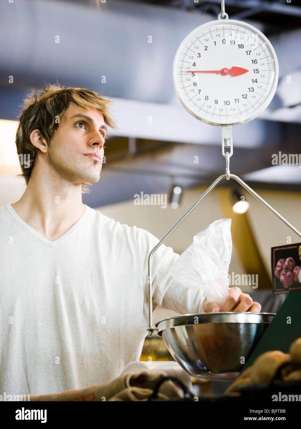 man using a scale at the supermarket Stock Photo - Alamy