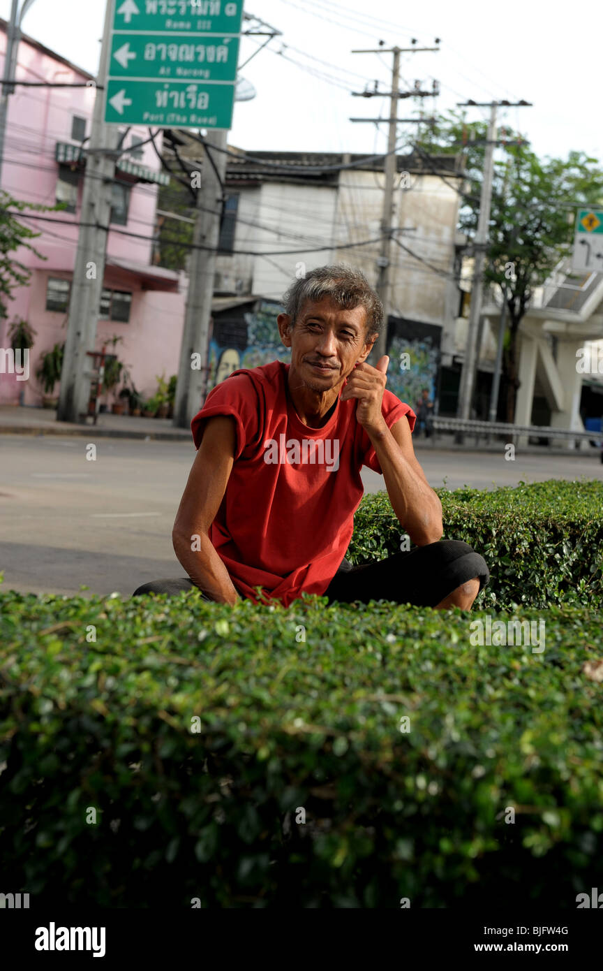 homeless man outside klong toei market , bangkok street scene , bangkok ...