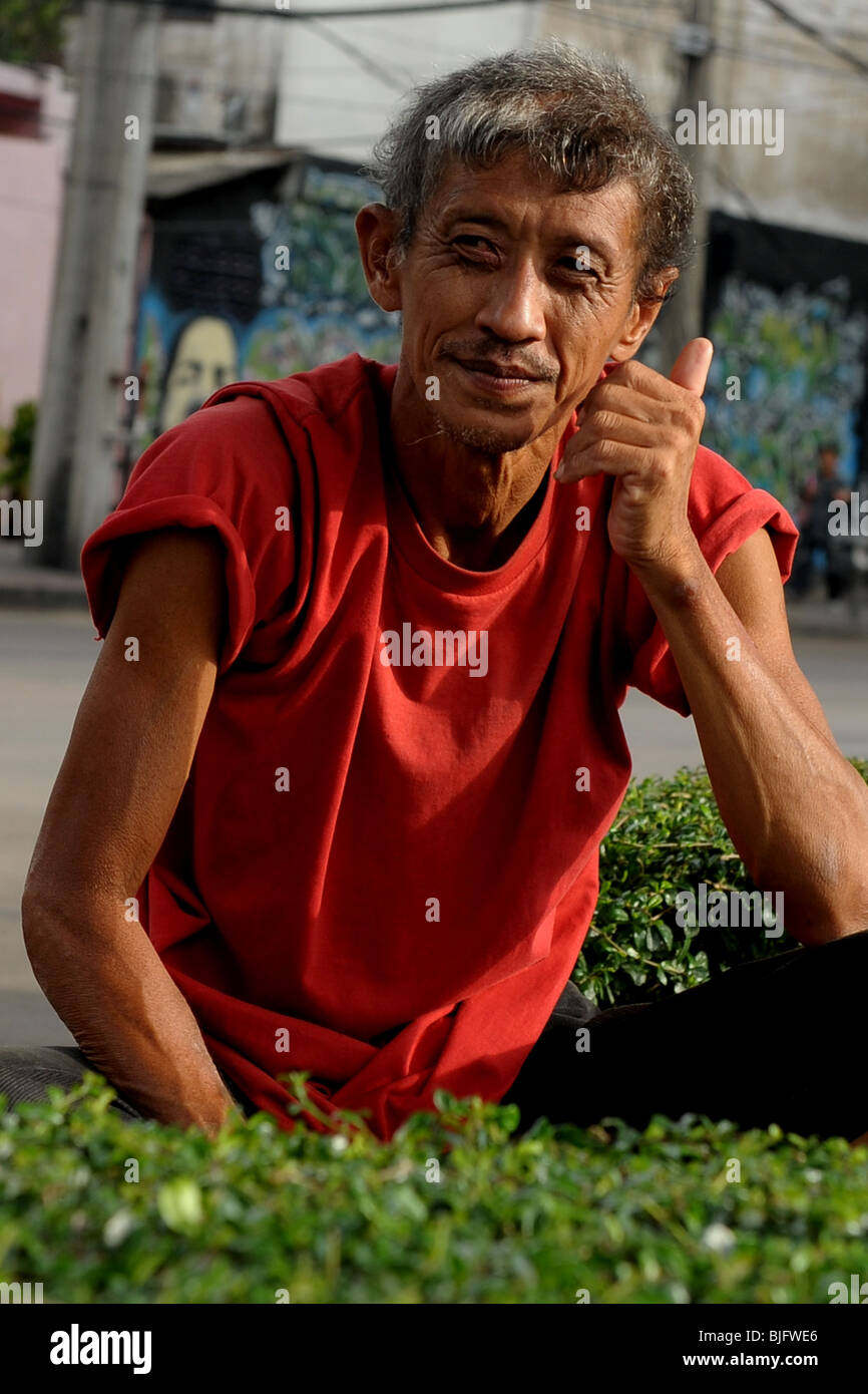 homeless man outside klong toei market , bangkok street scene , bangkok ...