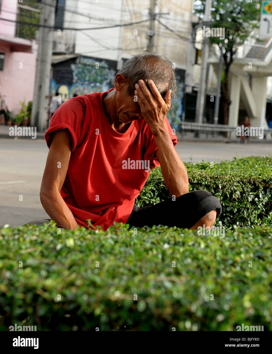 homeless man outside klong toei market , bangkok street scene , bangkok ...