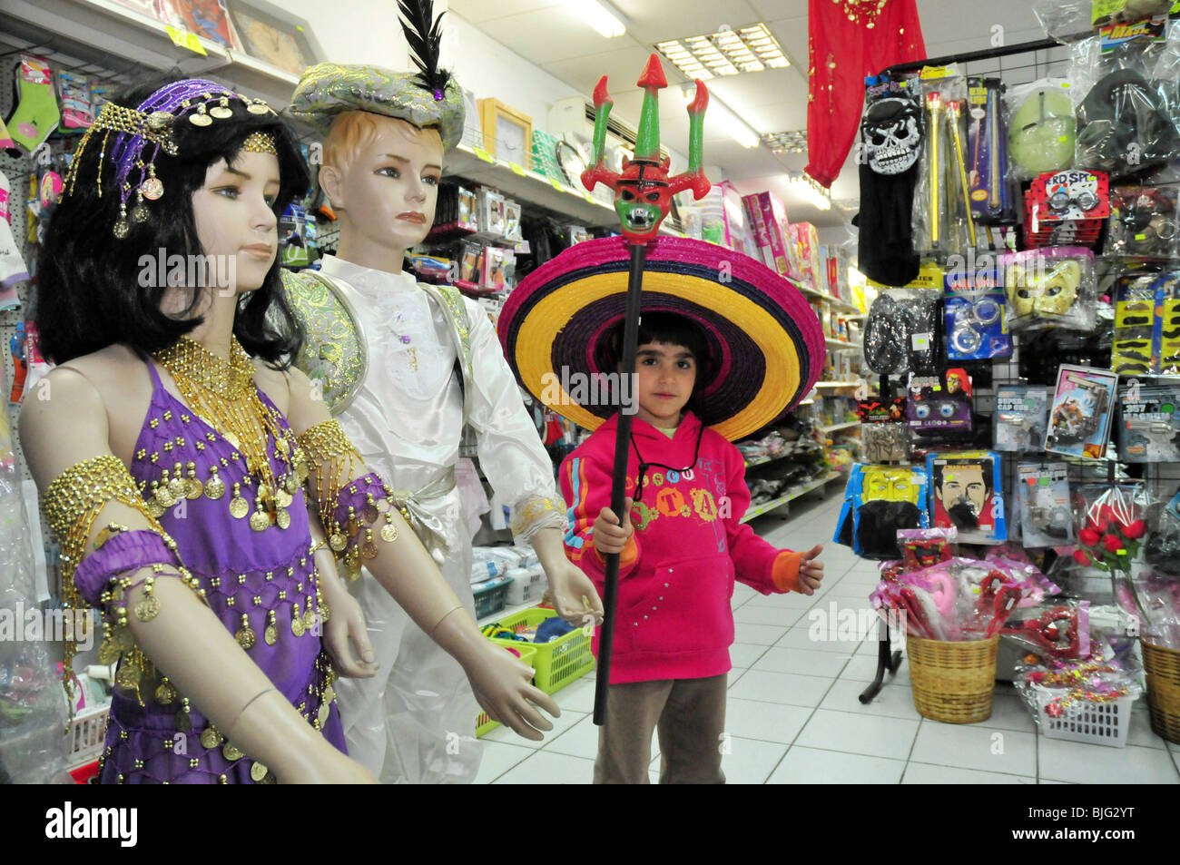 Israel, Purim A young Girl of 5 trying on Purim costumes in a toy store ...