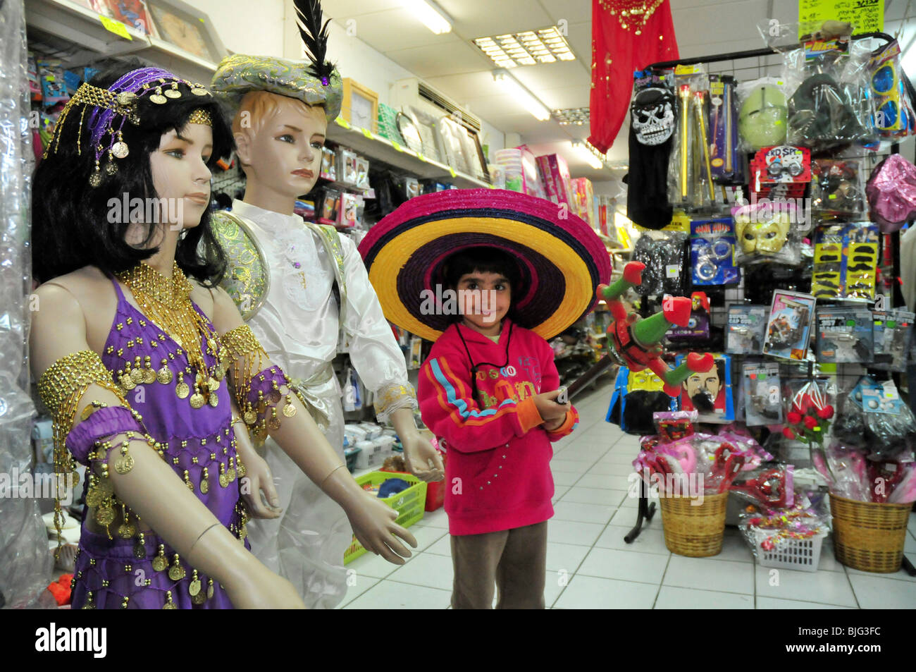 Israel, Purim A young Girl of 5 trying on Purim costumes in a toy store ...