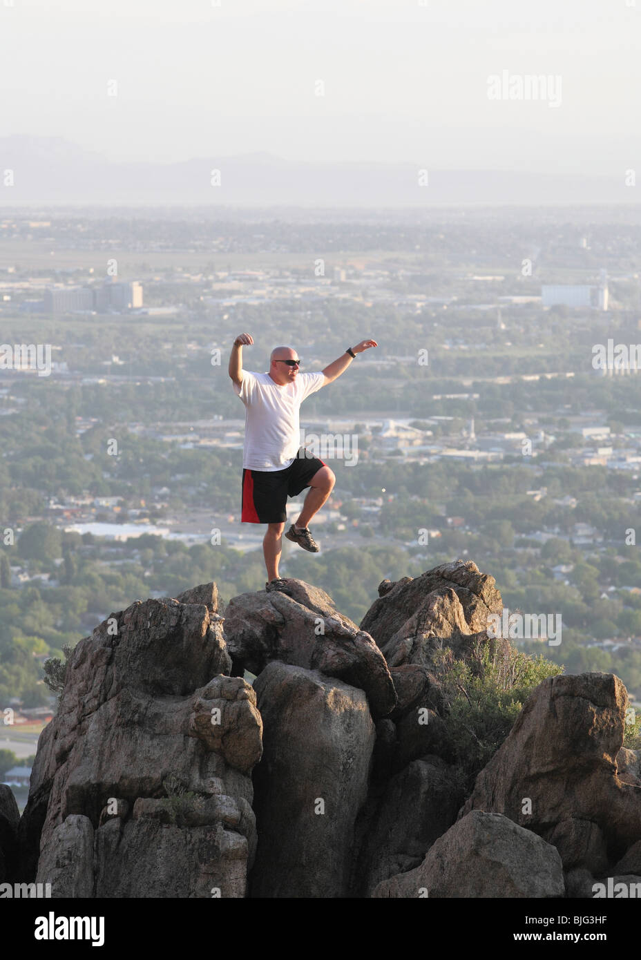 large adult male hiker standing on top of mountain in yoga pose Stock ...