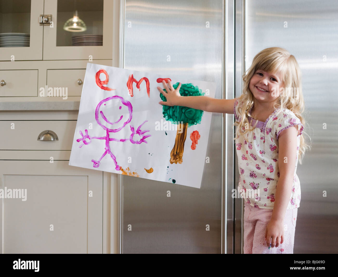 little girl holding up a drawing Stock Photo - Alamy