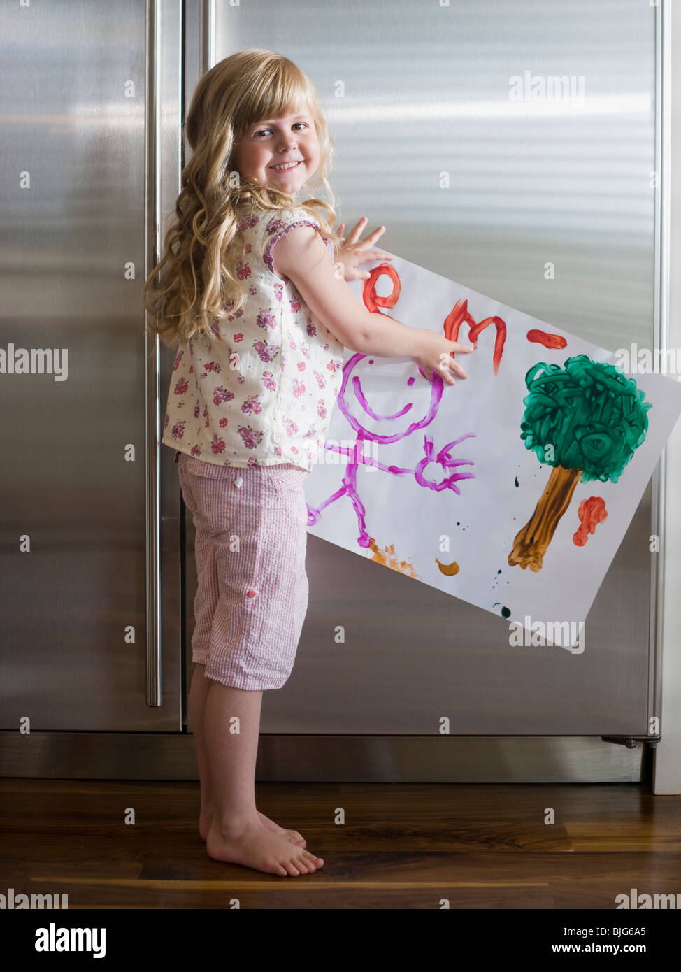 little girl holding up a drawing Stock Photo - Alamy