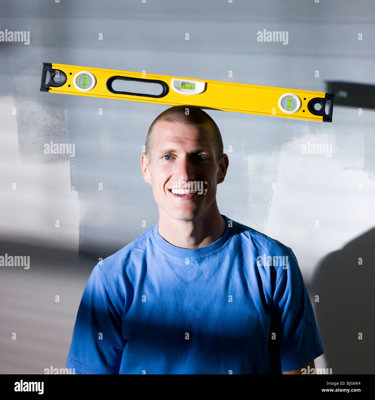 man balancing a level on his head Stock Photo - Alamy