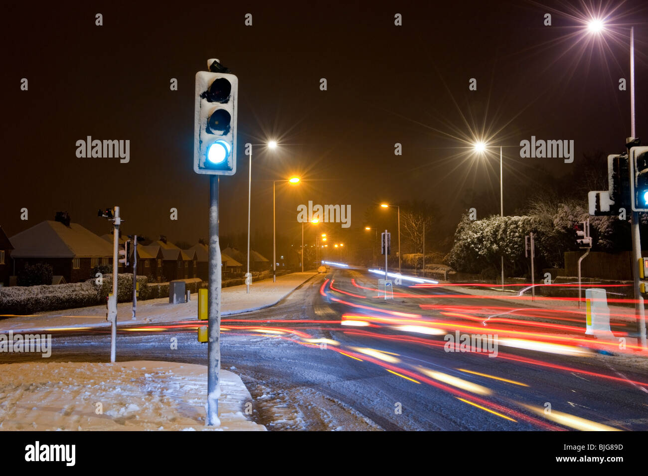 Main road with snow and car headlight trails at night Stock Photo - Alamy