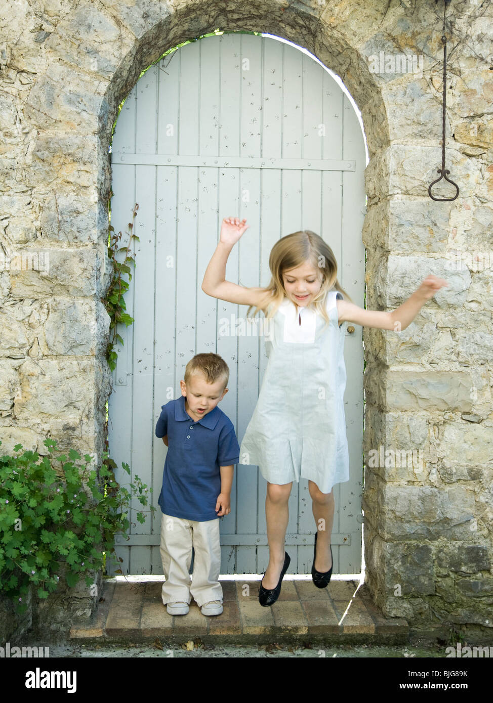 brother and sister jumping off a step Stock Photo - Alamy