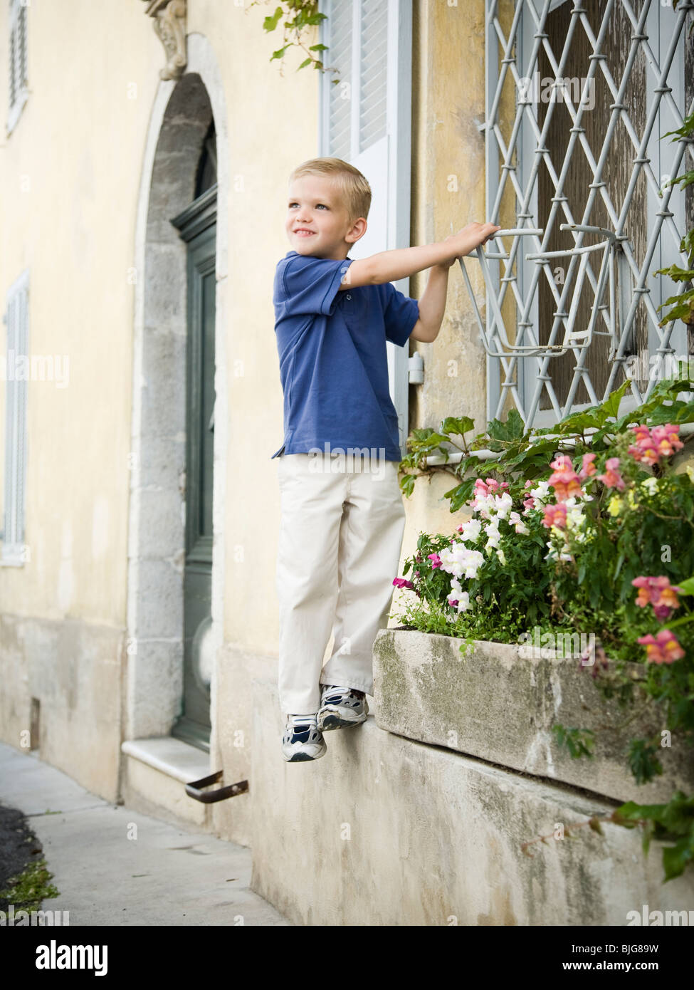 little boy climbing on a window Stock Photo - Alamy