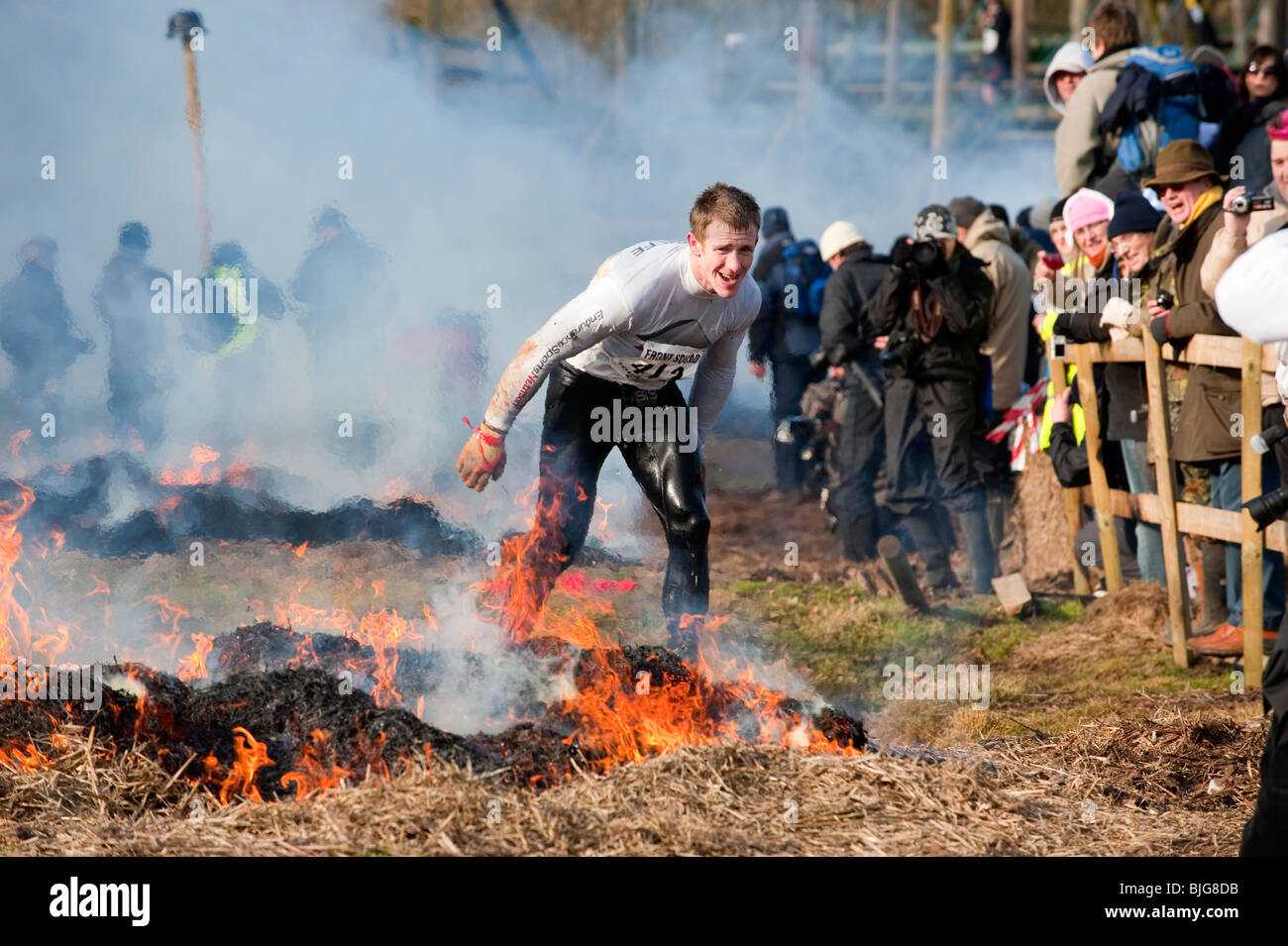 Runner running through flames and burning hay Stock Photo - Alamy
