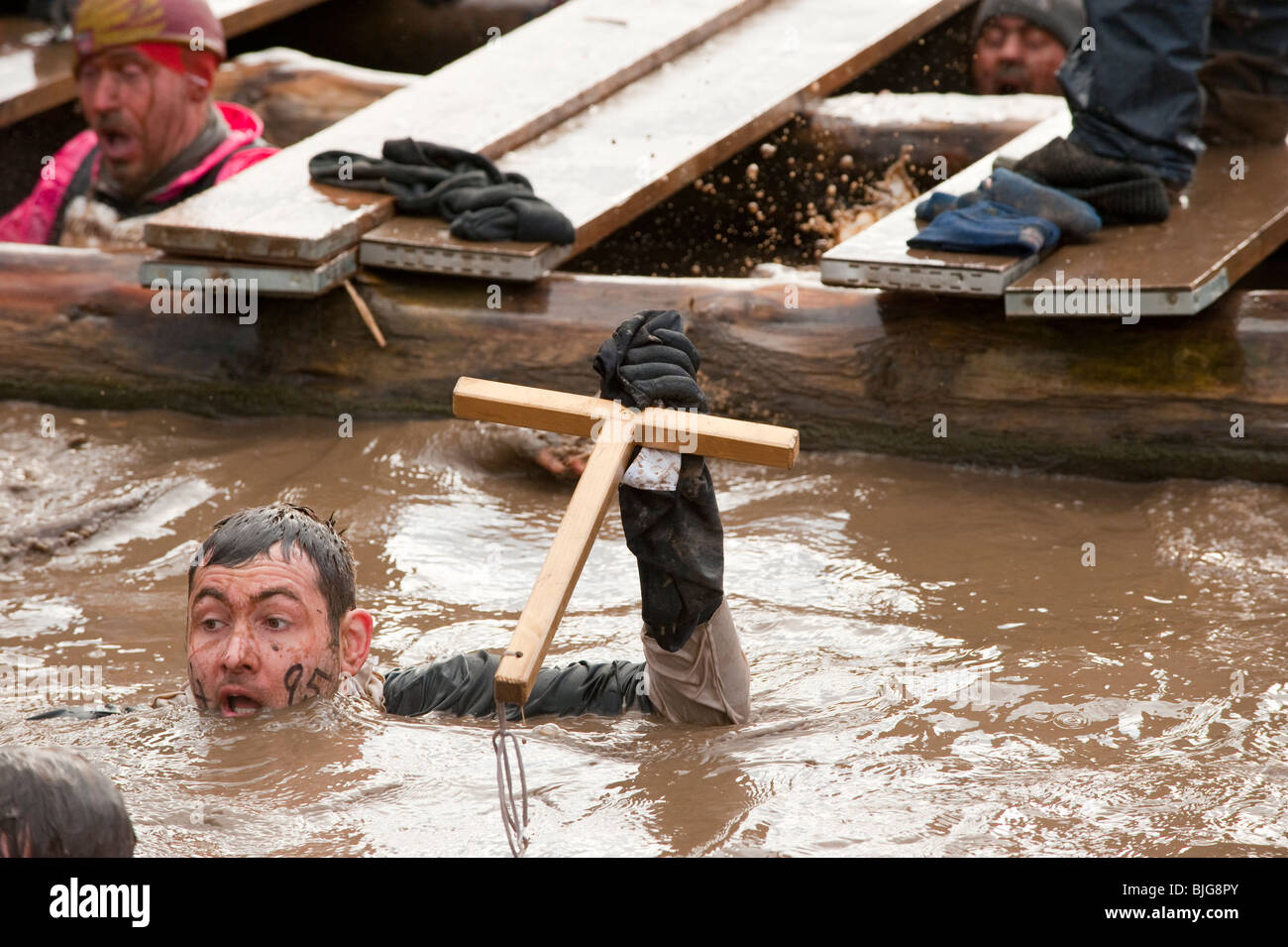 Man with Crucifix wading through deep muddy water Stock Photo - Alamy