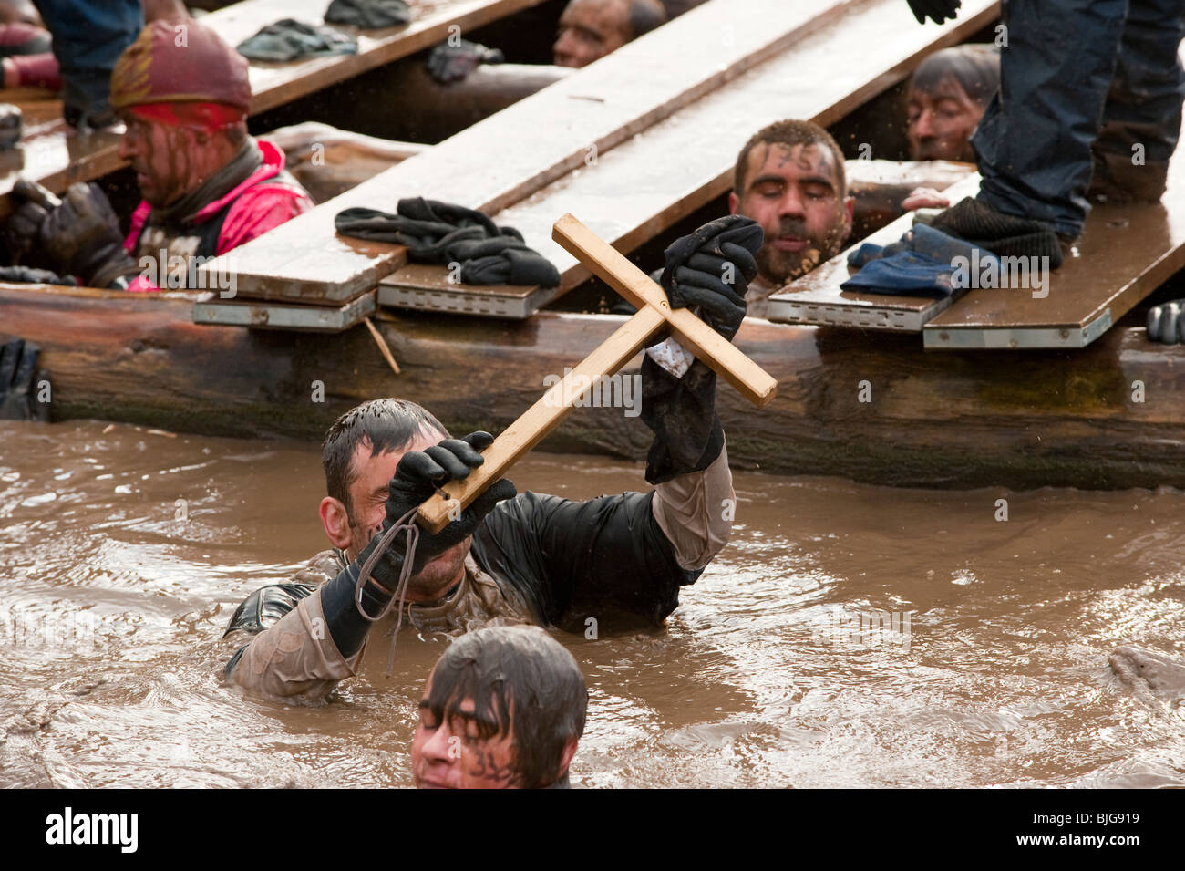 Man with Crucifix wading through deep muddy water Stock Photo - Alamy