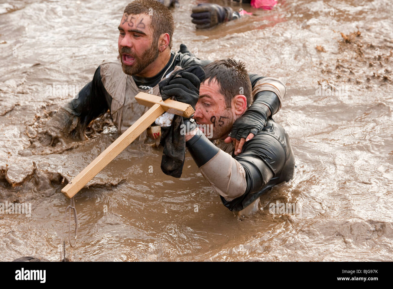 Man with Crucifix wading through deep muddy water Stock Photo - Alamy
