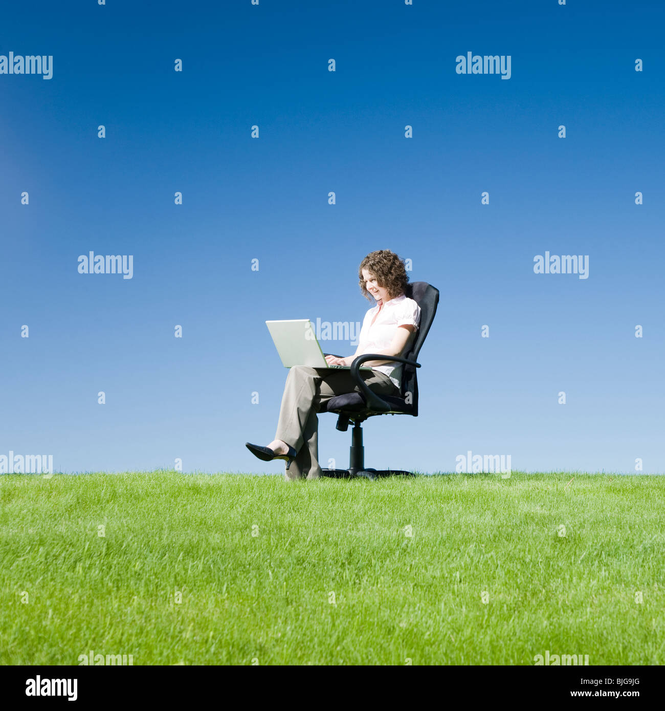businesswoman using her laptop in a busy field Stock Photo - Alamy