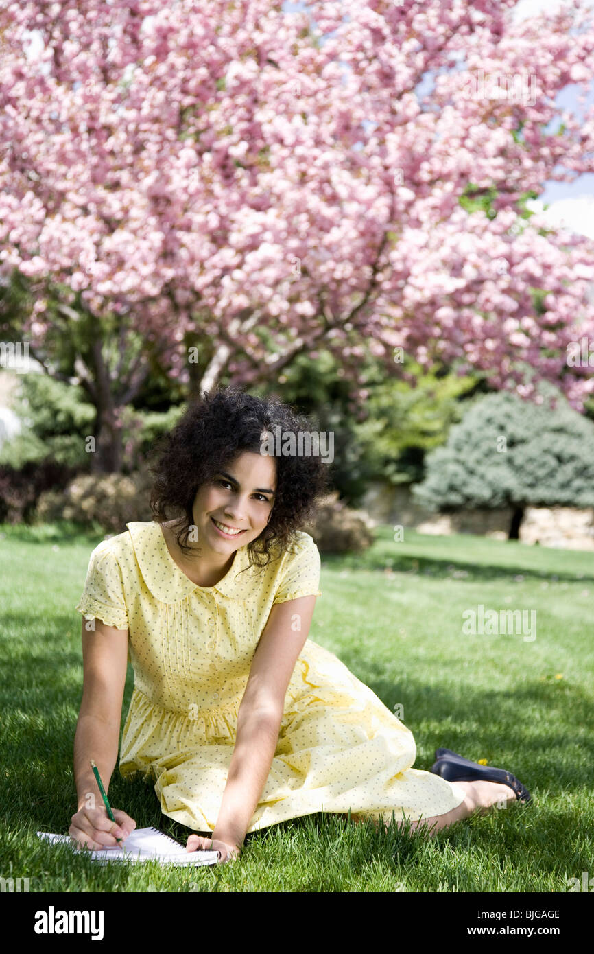 woman in a yellow dress writing Stock Photo - Alamy