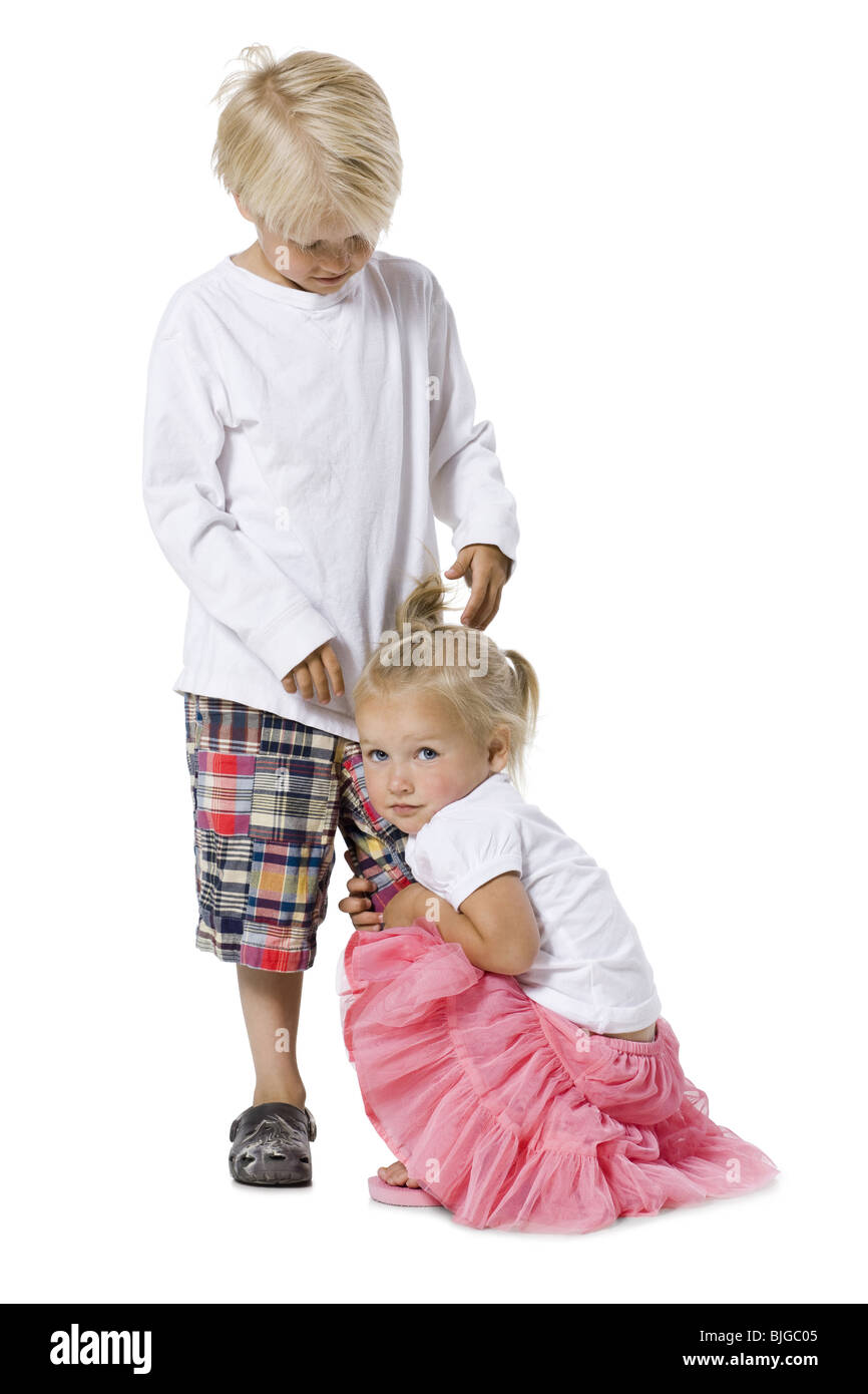 little girl holding on to her brother's leg Stock Photo - Alamy