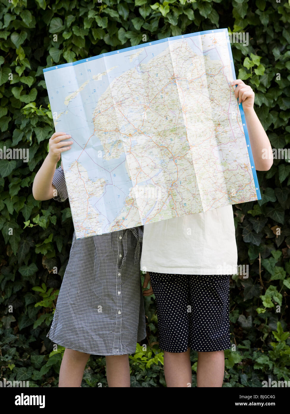 two girls holding a map Stock Photo - Alamy