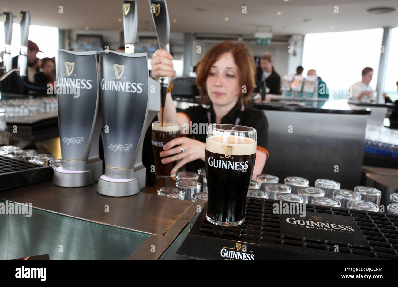 Woman taps Guinness beer in a bar, Dublin, Ireland Stock Photo - Alamy