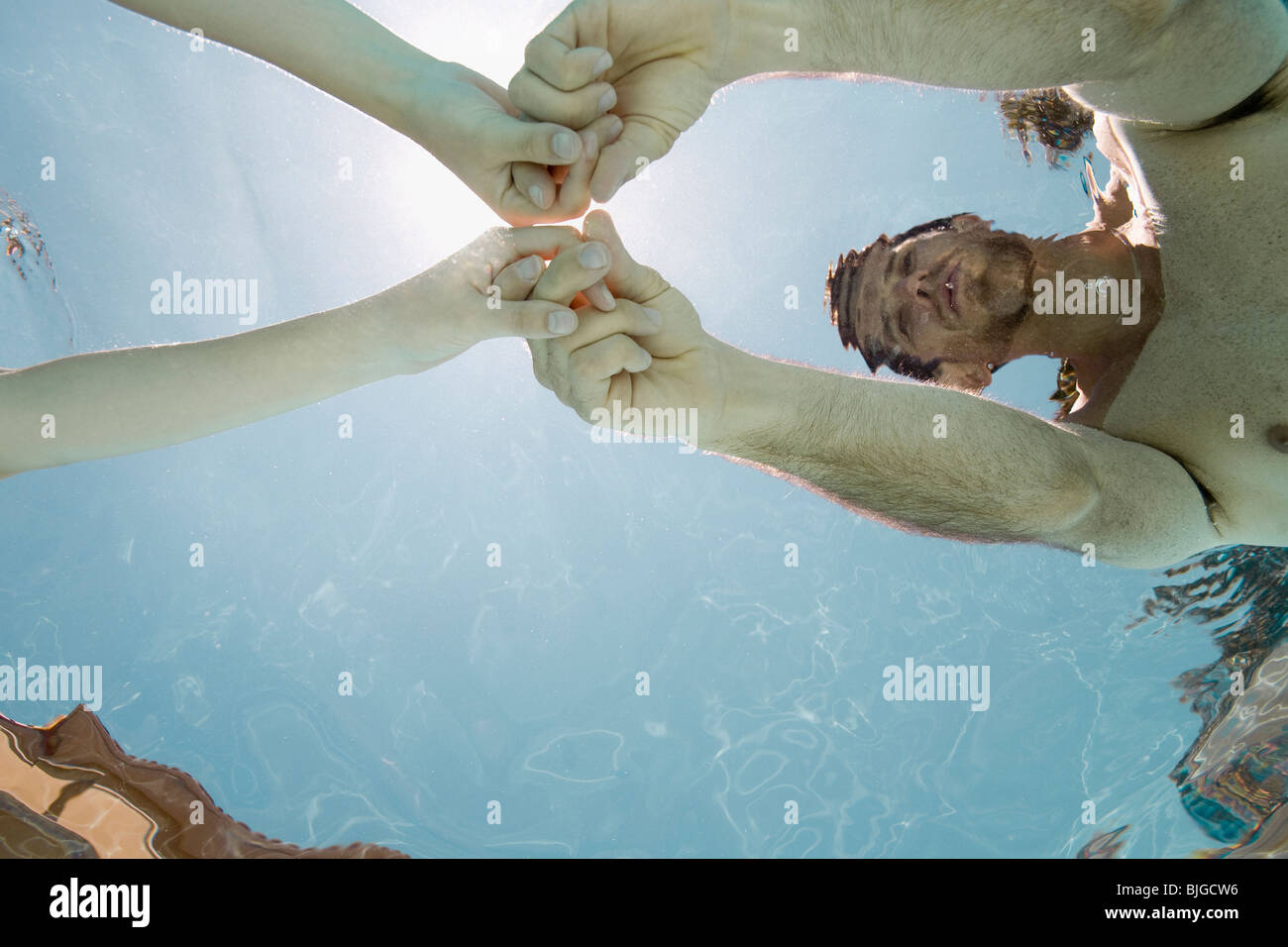 Couple holding hands swimming underwater hi-res stock photography and ...