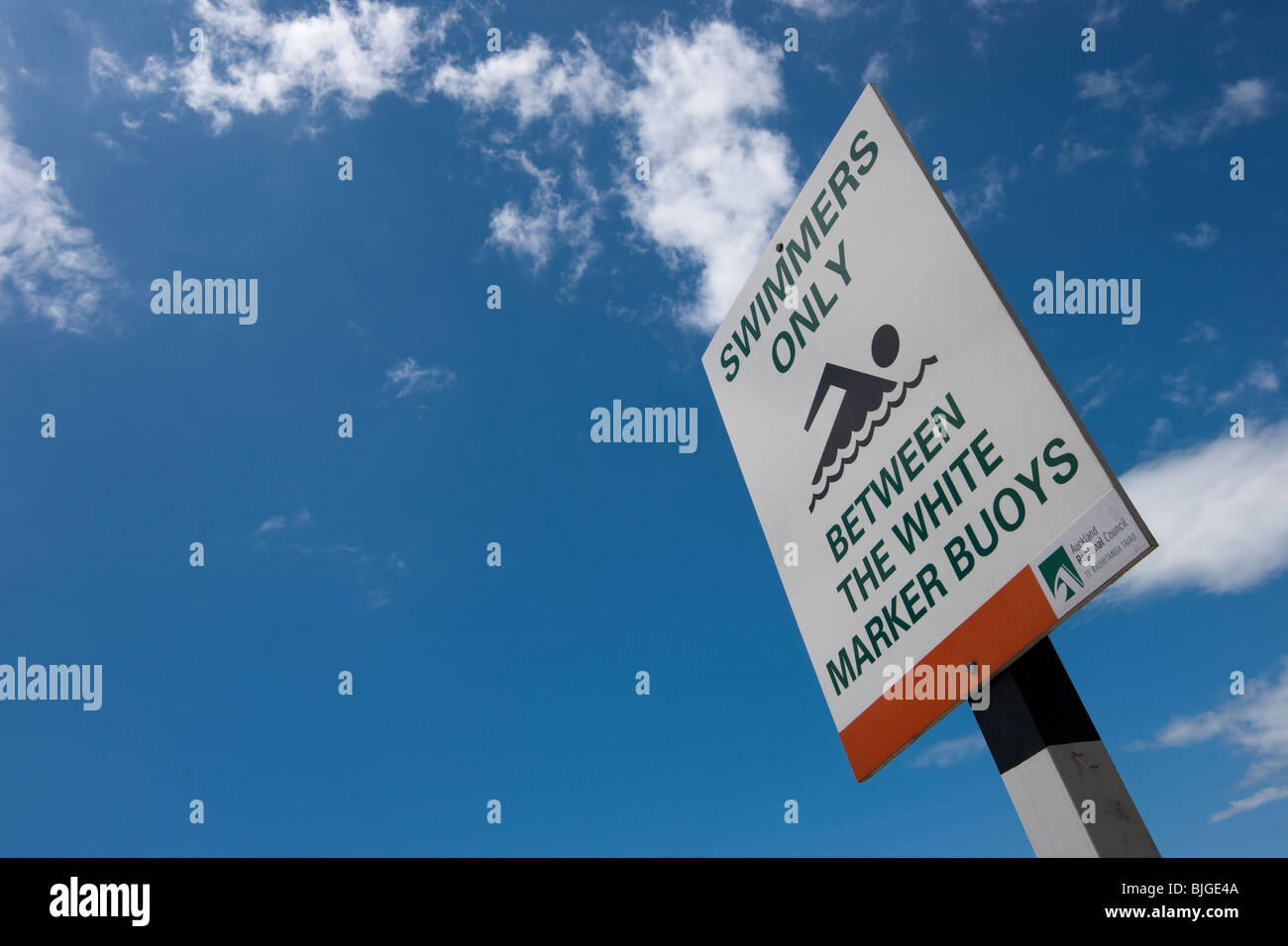 Sign saying swimmers only between the white marker buoys Stock Photo ...