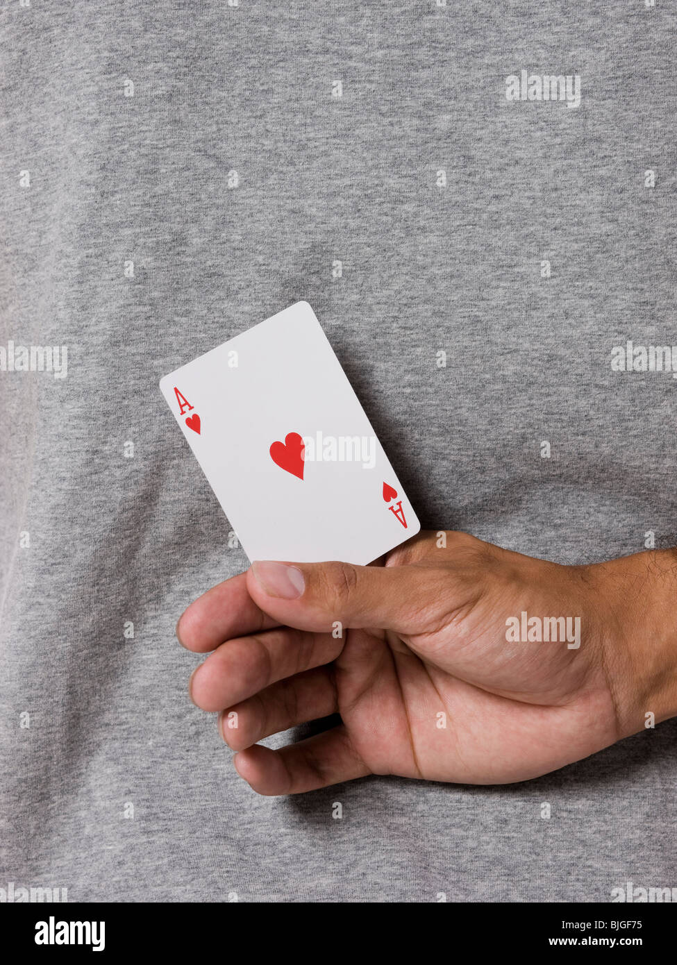 man holding an ace card behind his back Stock Photo - Alamy