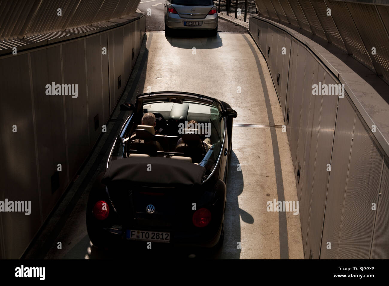 Convertible car Volkswagen Beetle driving out of underground parking ...