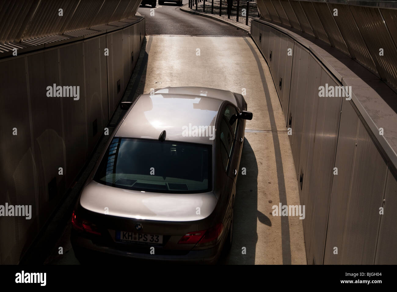 Car driving out of underground parking garage rear elevated view ...