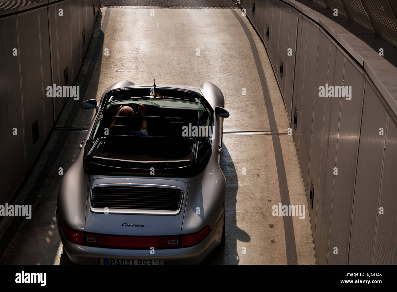 Convertible sports car Porsche Carrera driving out of underground ...