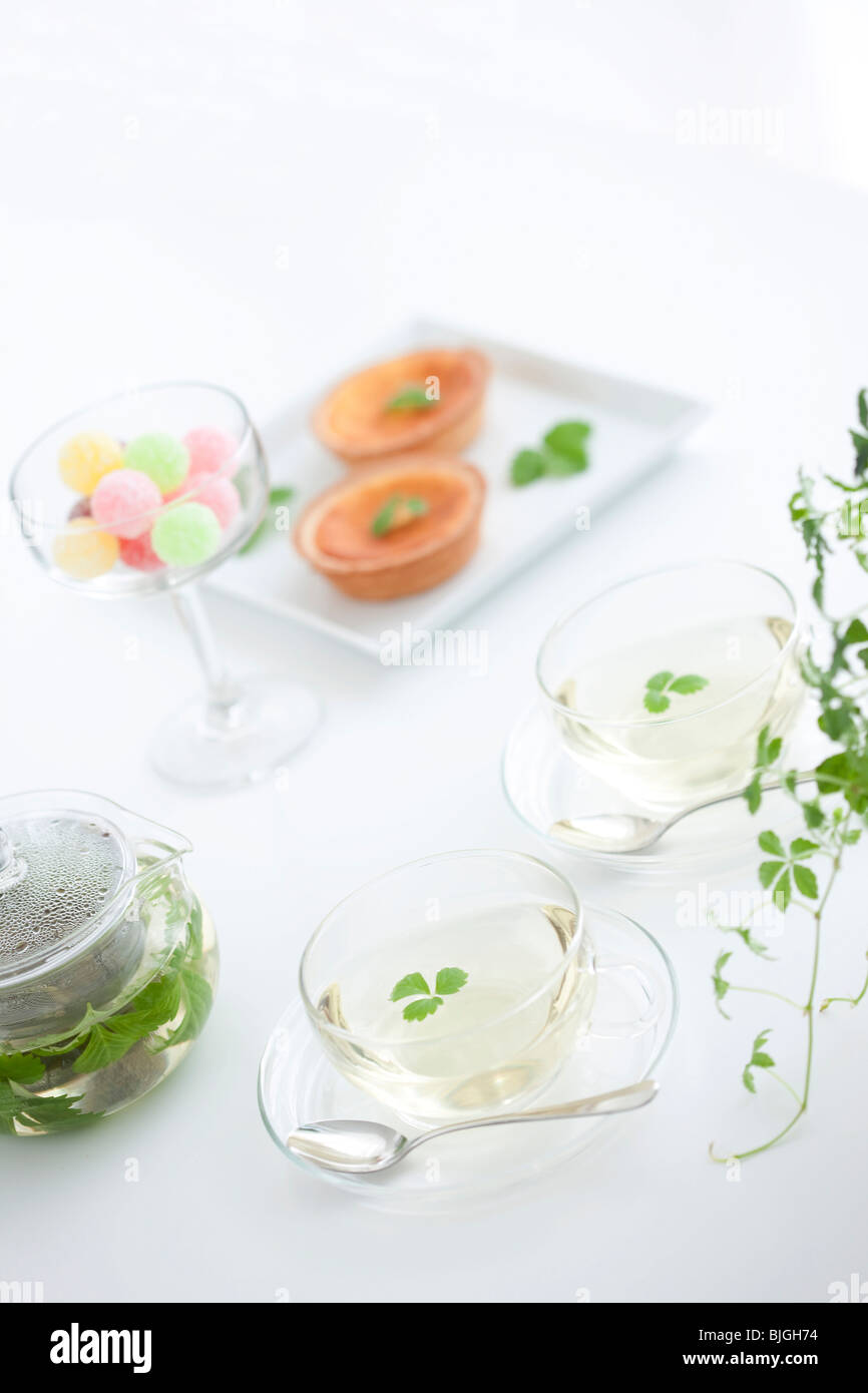 Herbal tea, a glass of candy and tarts Stock Photo - Alamy