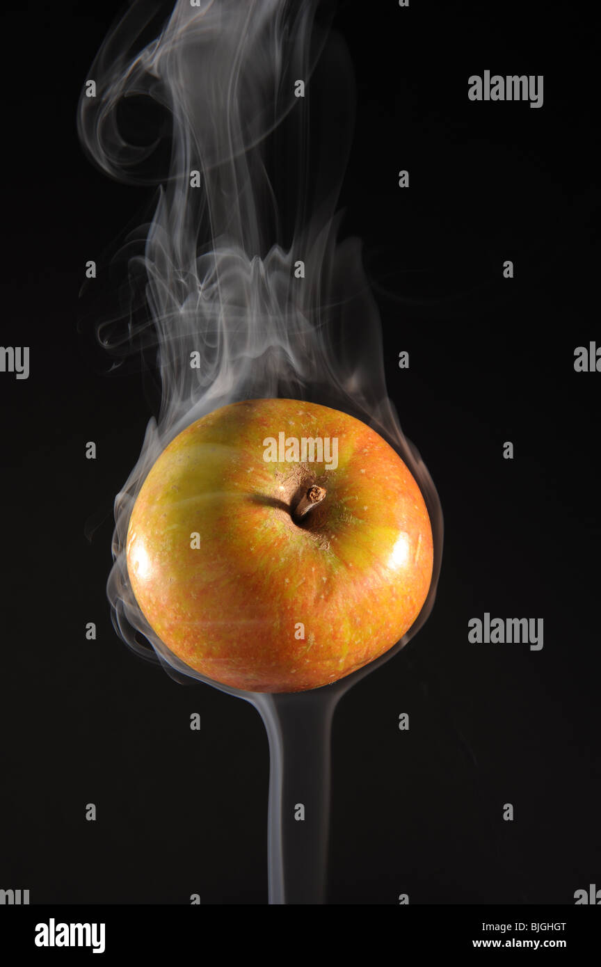 Smoking apple against black background Stock Photo - Alamy