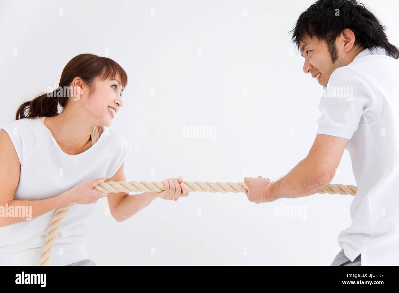 Man and woman playing tug-of-war Stock Photo - Alamy
