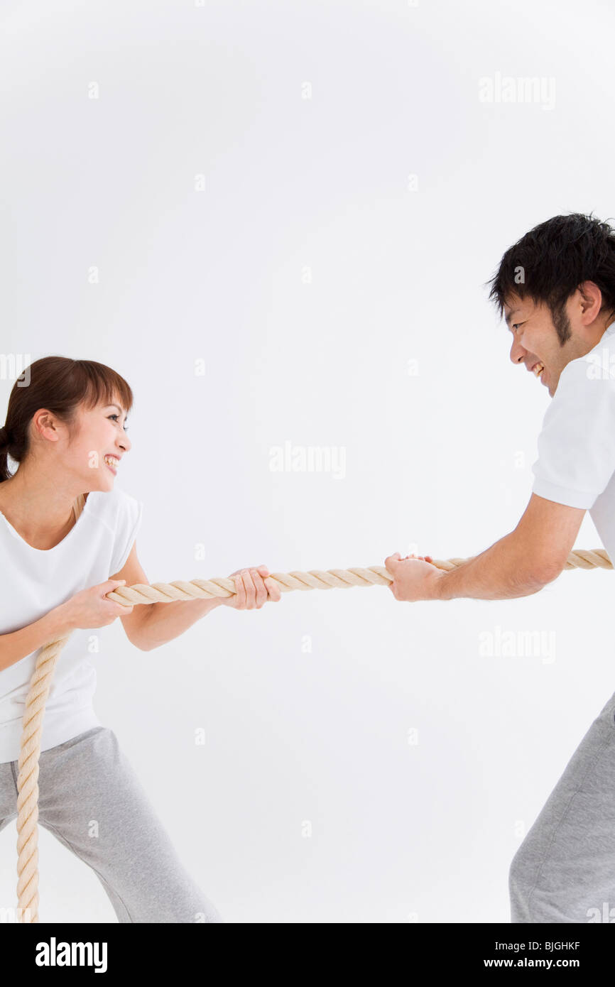 Man and woman playing tug-of-war Stock Photo - Alamy