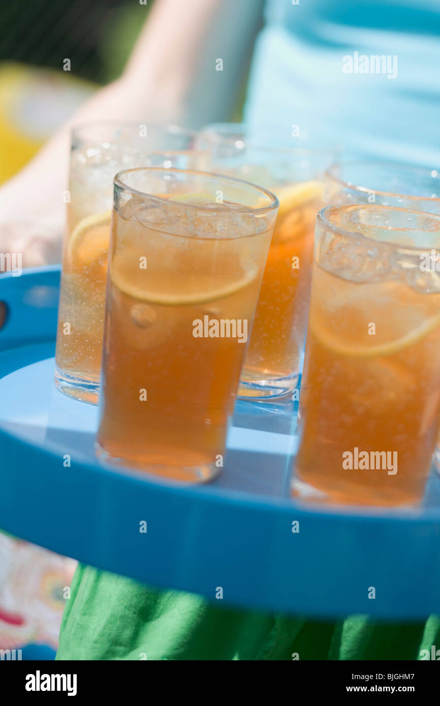 Person serving several glasses of iced tea on a tray Stock Photo - Alamy
