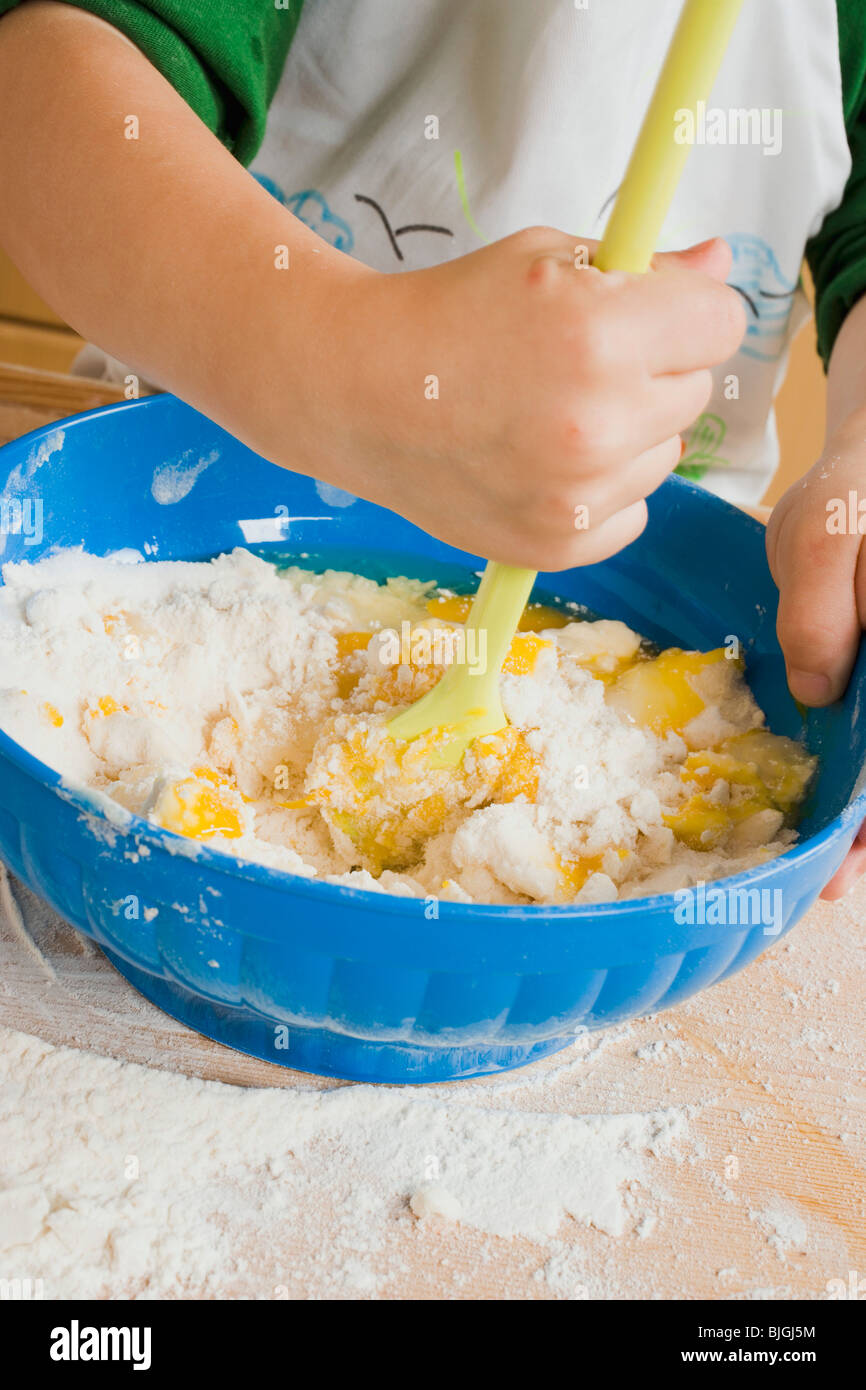Child mixing egg with flour and butter in a bowl Stock Photo - Alamy