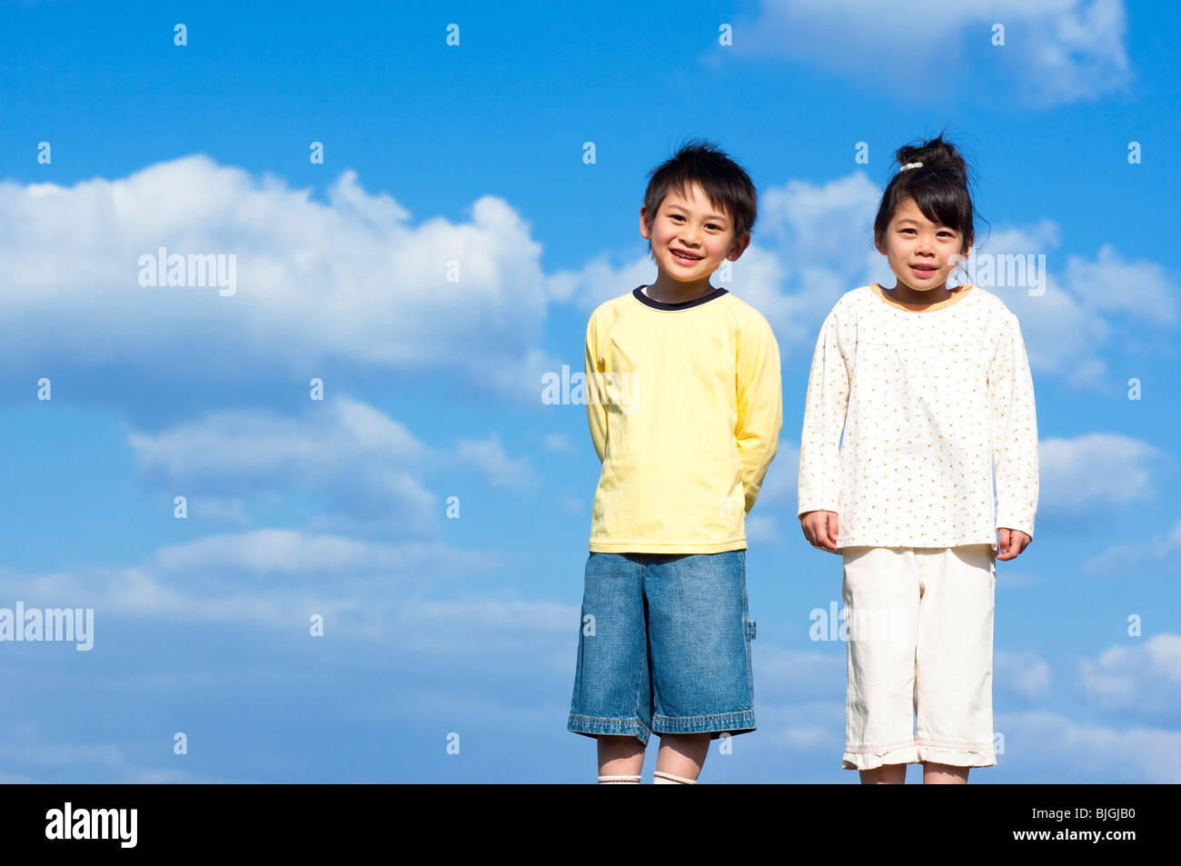 Portrait of brother and sister against a blue sky Stock Photo - Alamy