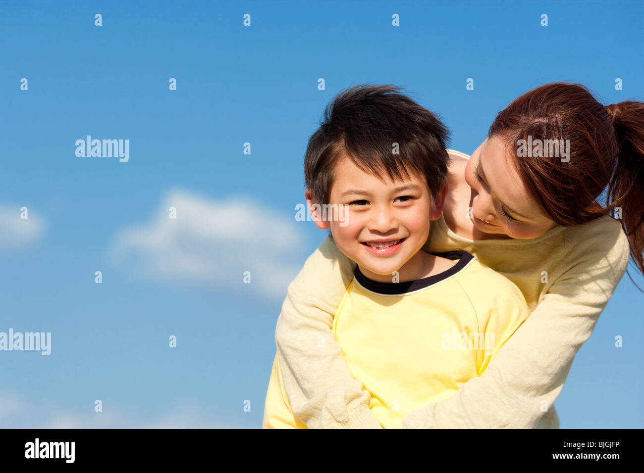 Mother hugging her son against a blue sky Stock Photo - Alamy