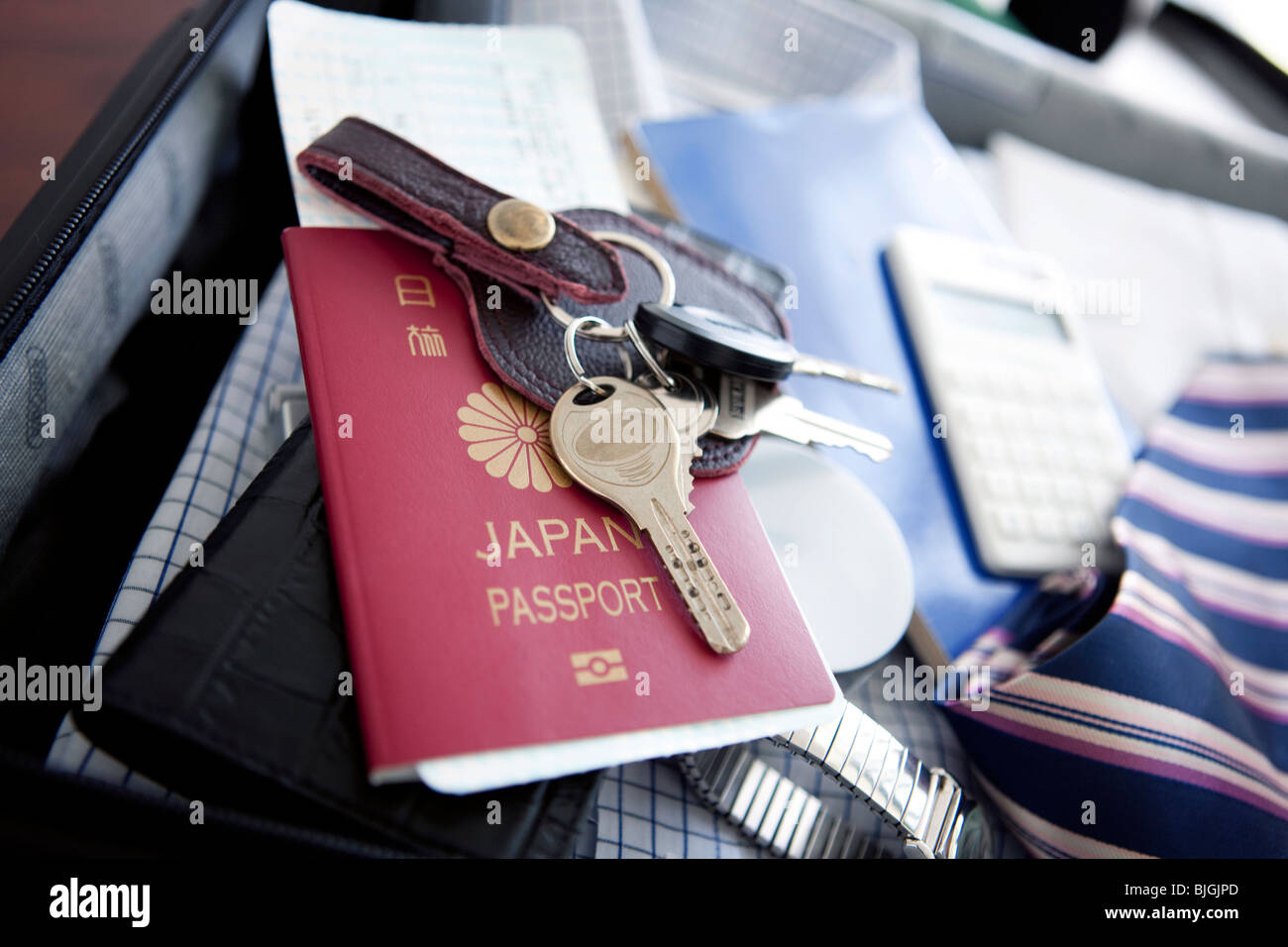 Passport and keys on top of a packed suitcase Stock Photo - Alamy