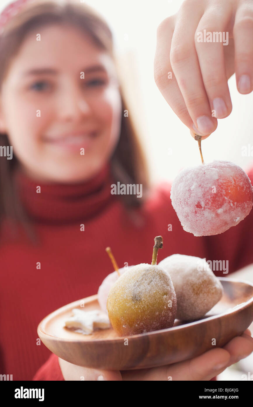 Young woman holding sugared fruit Stock Photo - Alamy