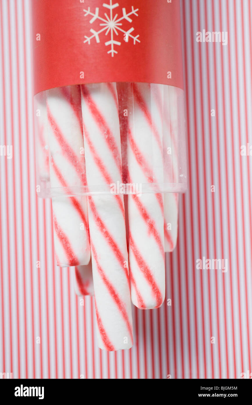 Candy canes in container on striped background Stock Photo - Alamy