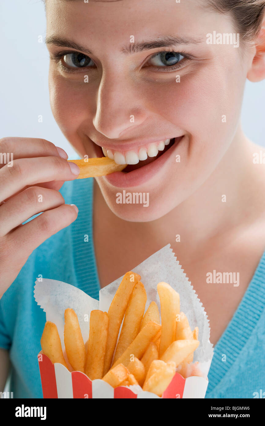 Young woman eating chips Stock Photo - Alamy