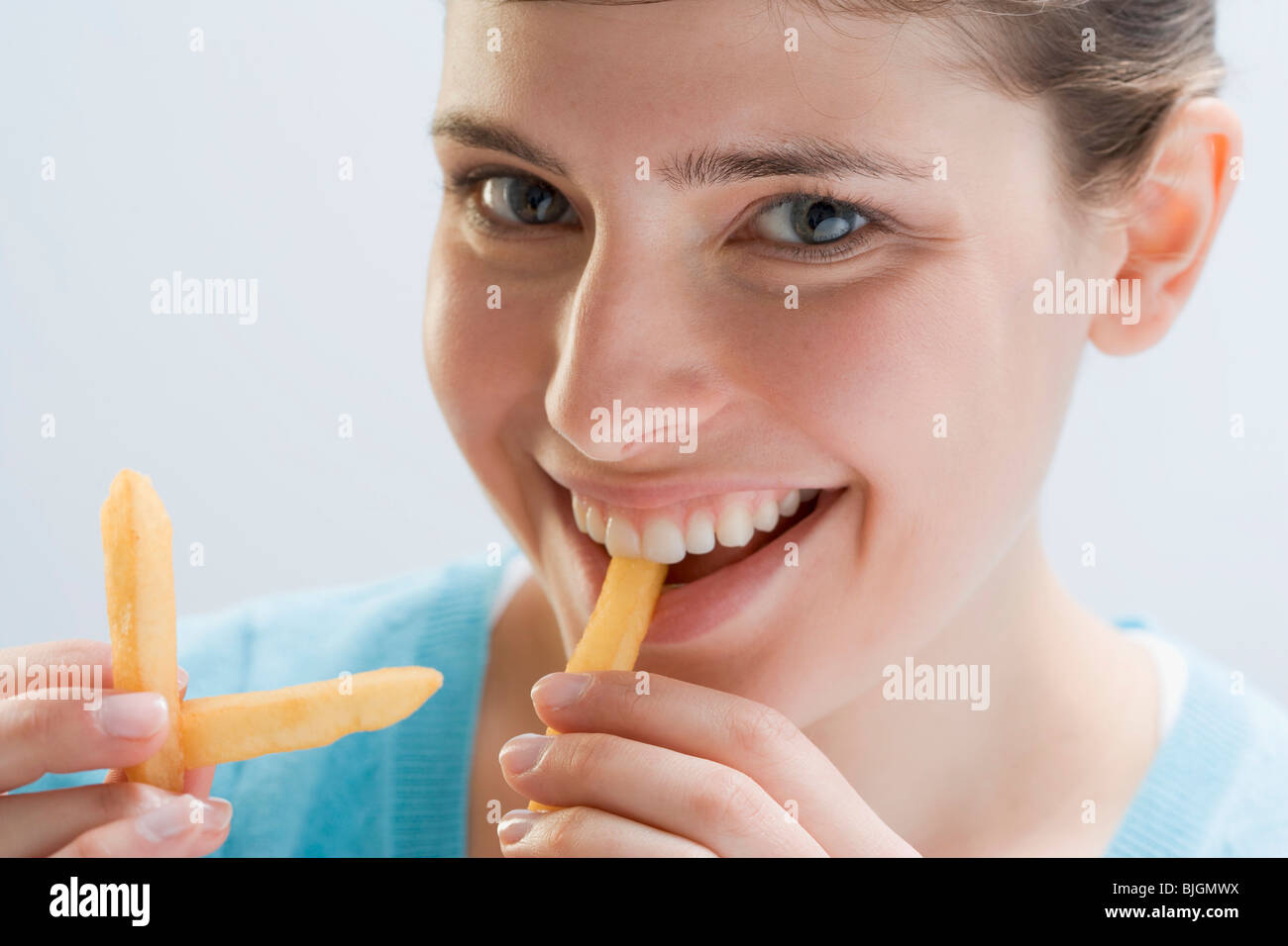 Young woman eating chips Stock Photo - Alamy