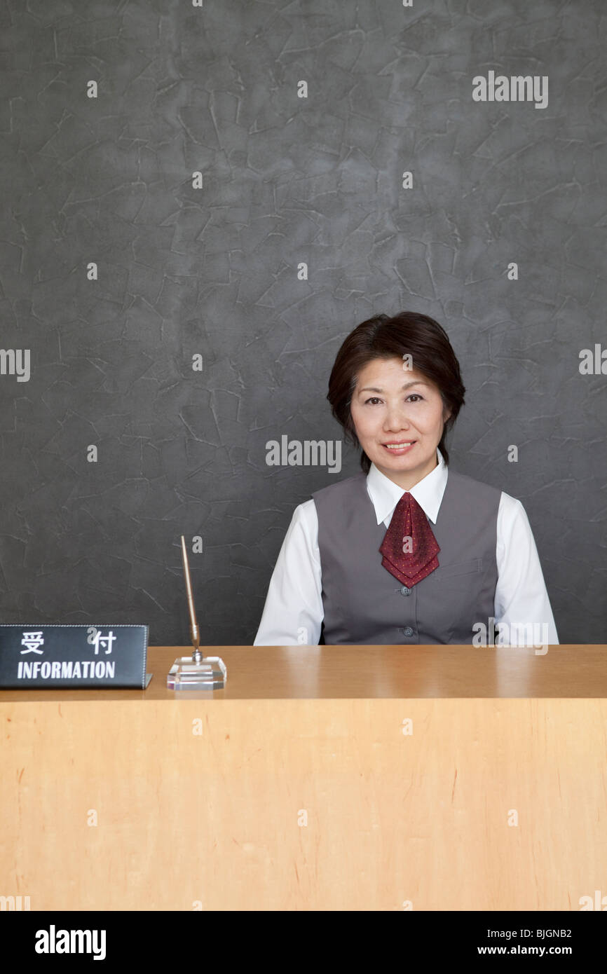 Woman sitting at information desk Stock Photo - Alamy