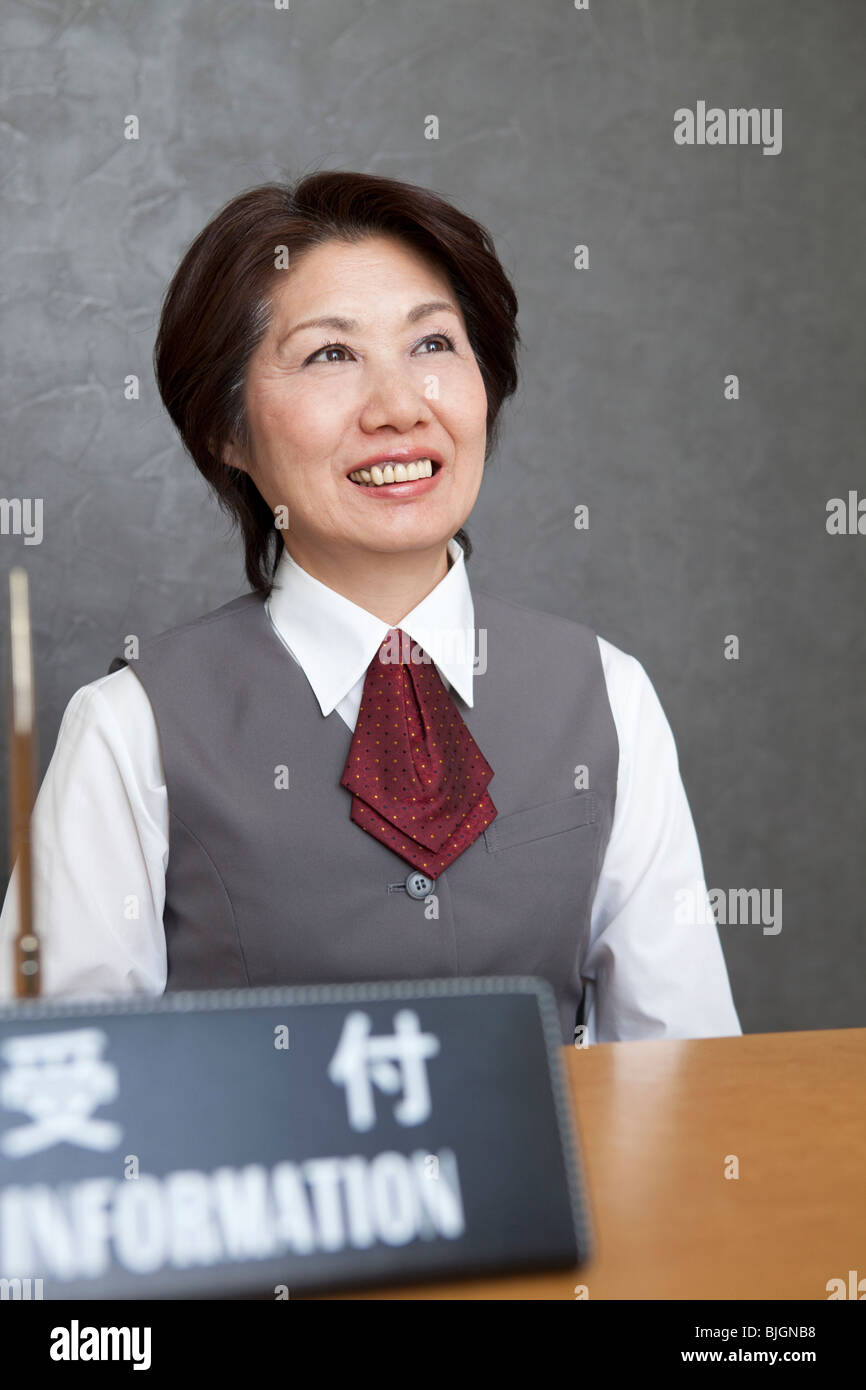 Woman sitting at information desk Stock Photo - Alamy