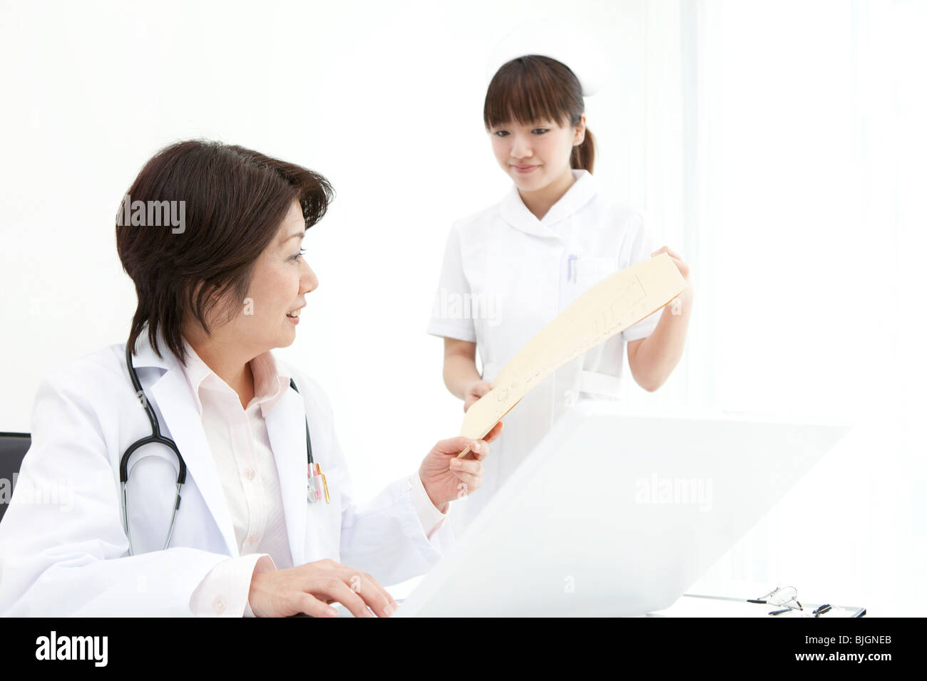 Nurse handing file to doctor Stock Photo - Alamy
