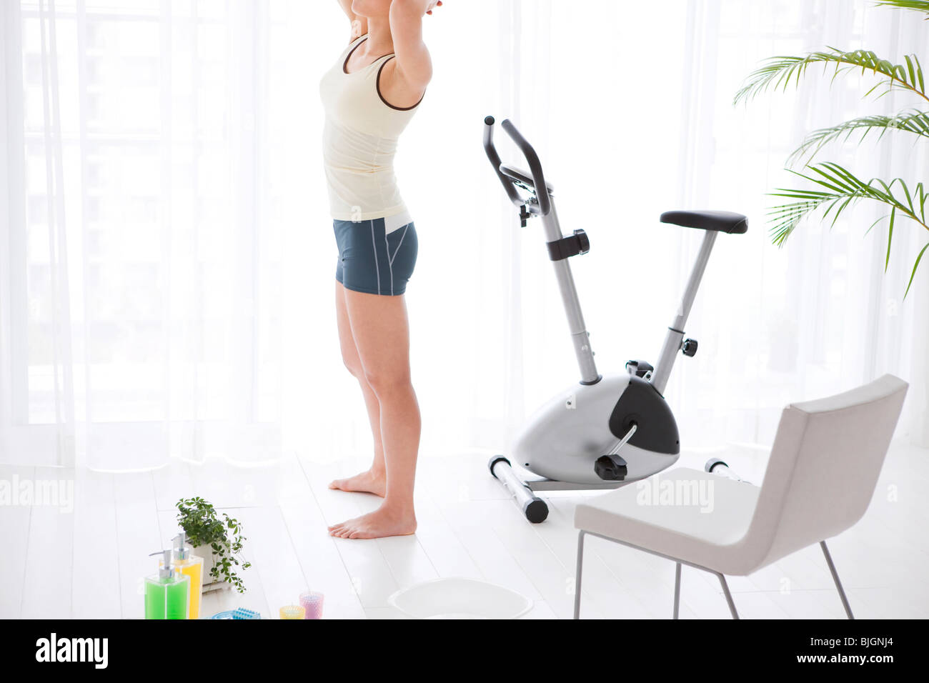 Woman standing next to an exercise bike Stock Photo - Alamy