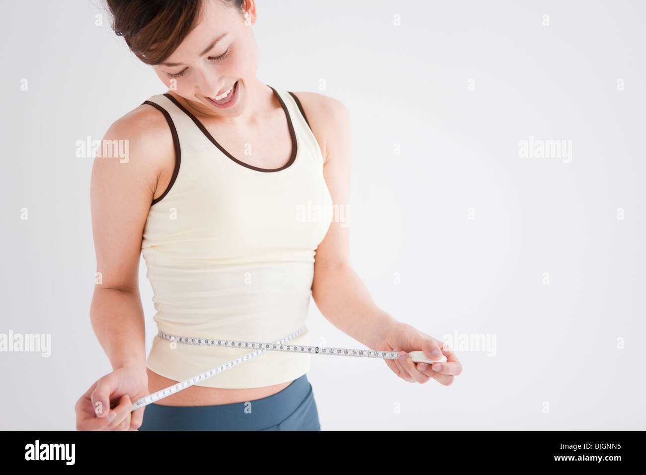 Woman measuring her waist Stock Photo - Alamy