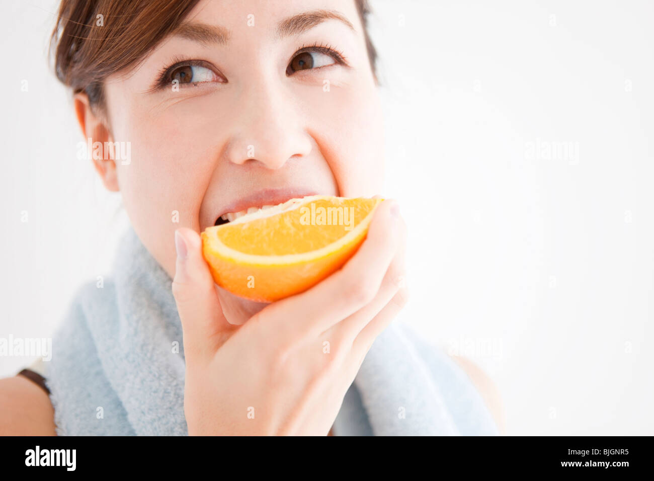 Woman eating an orange Stock Photo - Alamy